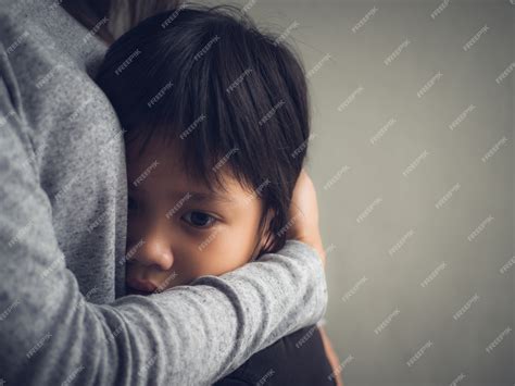 Niño Pequeño Triste Abrazado Por Su Madre En Casa Foto Premium