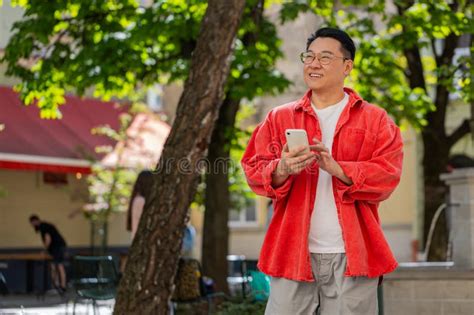 Asian Middle Aged Man Using Smartphone Typing Text Messages In Social Media Application Online