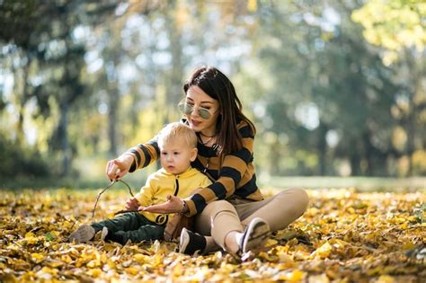 Madre E Hijo En El Parque De Otoño Foto Gratuita