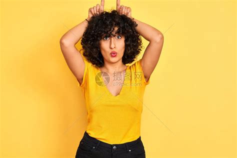 身穿T恤衫卷发的阿拉伯青年妇女站在孤立的黄色背景上站立高清图片下载 正版图片503683891 摄图网