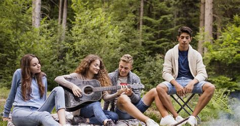 숲에서 캠핑을 하고 모닥불 옆에 앉아 기타를 연주하는 소녀 사진 Unsplash의 자연 이미지