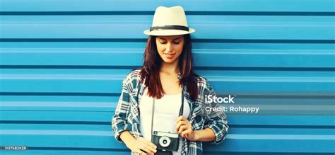 파란색 배경에 여름 밀짚 모자를 쓴 필름 카메라를 가진 젊은 여성 사진 작가의 초상화 관광에 대한 스톡 사진 및 기타 이미지 관광 관광객 여름 Istock