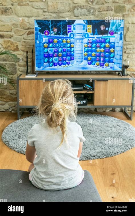 A 5 Five Year Old Girl Playing A Video Game On A Large Screen Stock