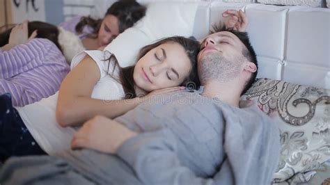 Friends Tired After The Party Sleeping Together On The Bed Stock