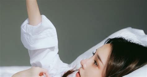 침대에 누워서 손에 든 붉은 사과를 바라보는 생각에 잠긴 젊은 여성 · 무료 스톡 사진