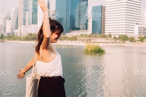 강 근처에 서서 방콕의 탁 트인 경치를 즐기고 팔을 흔들며 행복한 백인 여성 꽃 식물에 대한 스톡 사진 및 기타 이미지 꽃 식물 손 흔들기 30 34세 Istock