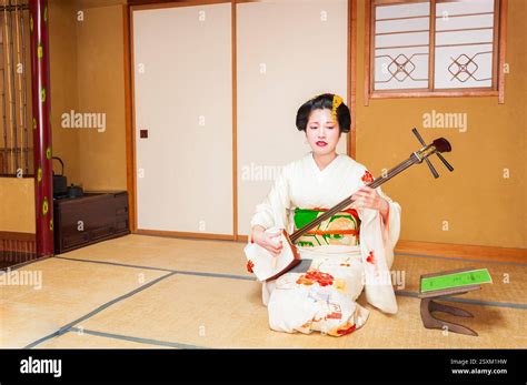 A Geisha Sits Playing The Three Stringed Traditional Japanese Shamisen On The Tradiotional
