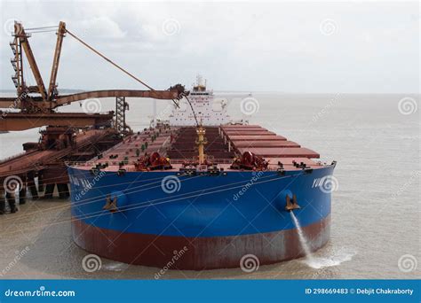 Ore Carrier Ship Moored At The Jetty Loading Iron Ore By Shore Loader