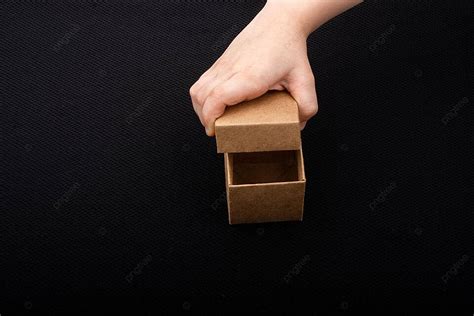 Unboxing With A Black Backdrop Hand Reveal Of Cardboard Box Photo