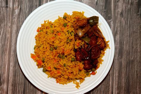 간장과 야채를 곁들인 매운 치킨과 야채 완두콩과 당근을 곁들인 뜨거운 찐 긴 곡물 노란색 바스 마티 쌀의 중국 음식 요리 식사