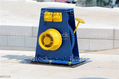 복원 빈티지 레트로 블루와 노란색 주철 풀 리 휠은 작은 보트와 함께 작업 하는 데 사용 되는 전통적인 돌 타일 부두에 장착 0