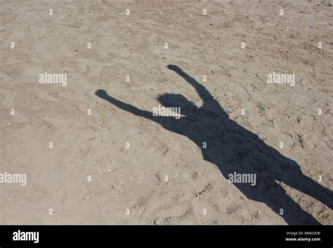 Shadow Of Man Doing Socialism Sign On Sand Background Raised Fist Is A Symbol Of Solidarity And