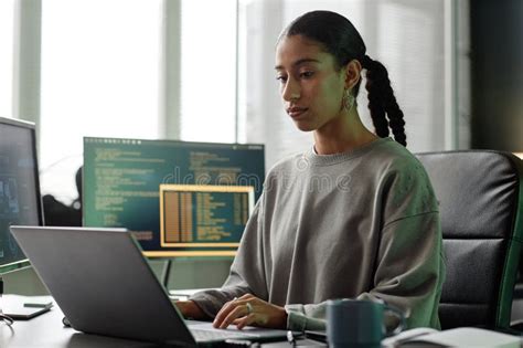 Middle Eastern Female Programmer Using Laptop Sitting At Workstation In
