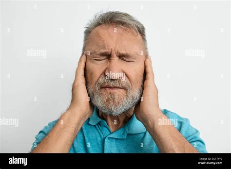 Elderly Man Feels Discomfort In His Ear Illustrating The Challenges Of