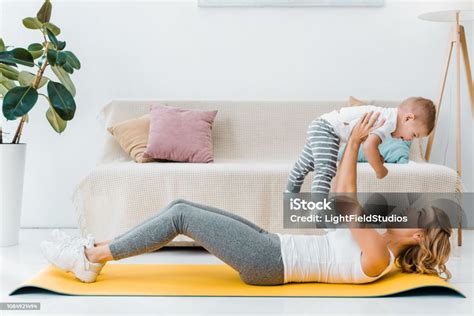 피트 니스 매트와 지주 귀여운 유아 소년에 거짓말 하는 여자 가정의 방에 대한 스톡 사진 및 기타 이미지 가정의 방 가족 거실 Istock