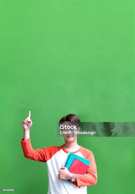 복사를 십 대 남자 포인트 머리 공간 및 교육 캠페인 개념에 광고에 대 한 디자인의 콘텐츠를 추가 하기 위한 공간을 복사 대학 캠퍼스 녹색 벽에 노트북을 들고 공란에 대한