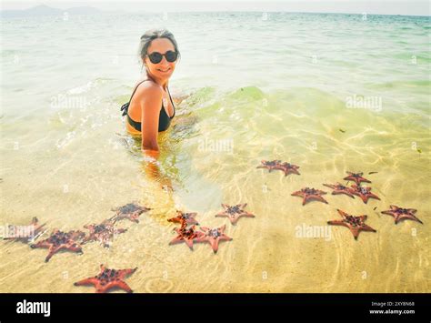 Woman Tourist Visit Star Fish Beach Pick Starfish In Famous Tropical