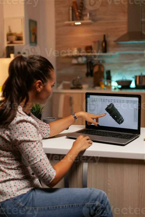 Engineer Pointing At Turbine Project On Laptop While Working On Laptop During Night Time