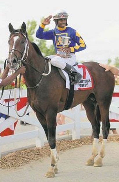 Jalon Samuel waves from the winner's circle after riding Street Prancer ...