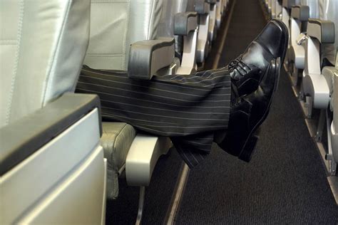 Plane Passenger Assumes Bizarre Position To Steal Neighbors Leg Room