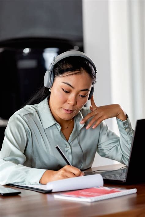 Young Asian Woman Working From Home Sitting In Front Of Laptop