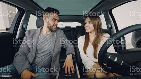 사랑 하는 남편 좋은 인테리어와 가죽 시트와 새로운 자동차 안에 앉아있는 동안 그의 행복 한 아내에 게 차 키를 주고 있다 흥분된 여자는 그에 게 들고 바퀴 키스는 차에
