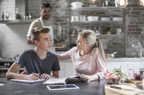 Mutter Hilft Ihrem Sohn Bei Den Hausaufgaben W Hrend Der Vater Kocht