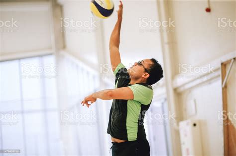 실내에서 비치 발리볼을 하는 남자의 남성 초상화 사람들과 함께하는 라이프 스타일 스포츠 사진 다인종 사람들은 스포츠 코트와 같은 체육관에서 공이있는 선글라스를 착용합니다
