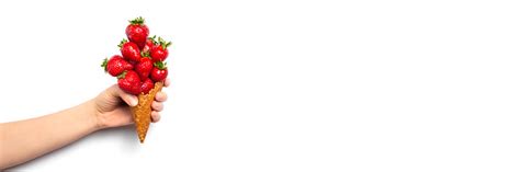 흰색 배경에 고립 된 잘 익은 딸기로 가득 찬 아이스크림 콘 잘 익은 딸기와 와플 콘을 들고 있는 여성의 손 복사 공간이 있는 긴 배너입니다 가득 찬에 대한 스톡 사진 및