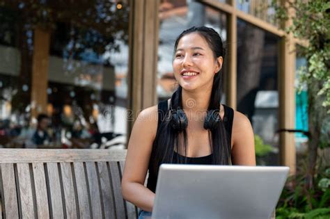 一个漂亮的女人坐在长椅上，一边用笔记本电脑工作一边望着一边做白日梦 库存图片 图片 包括有 长凳 白日梦 356090073