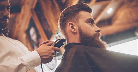 이발소에서 전기 면도기로 미용사에 의해 이발을 받는 젊은 수염 난 남자의 낮은 각도 보기 사진 Unsplash의 이발소 이미지