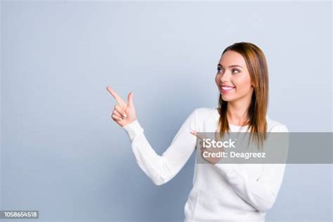 회색 배경에 고립 된 복사 공간 보고 빈 자리에 두 개의 Forefingers를 가리키는 백색 스웨터에서 세련 된 유행 여자의 초상화 여자 사업가에 대한 스톡 사진 및 기타