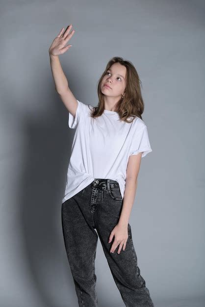 Teenage Girl Stands With One Hand Raised As If Reaching For Something