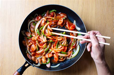 일본식 파스타 요리 스파게티 조리법 및 재료 스파게티 고추 위너 양파 케첩 강판 치즈는 유리 용기에 들어 있습니다 할머니는 젓가락과 케첩을 프라이팬에 튀긴 재료와 섞어