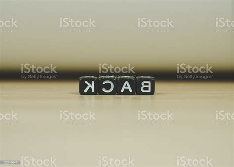 흰색 배경에 나무 바닥에 큐브로 쓰여진 다시 단어 문자 블록은 텍스트 또는 기타 이미지 또는 디자인을 추가하기위한 Back 단어로 정렬됩니다 개념에 대한 스톡 사진 및 기타