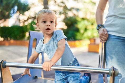 Madre E Hijo Jugando Al Swing En El Parque Infantil Foto De Archivo
