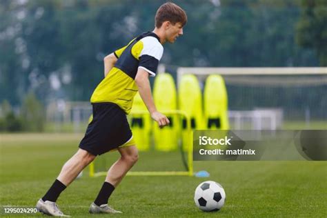 훈련장에서 축구공을 달리는 소년 잔디 밭에서 축구를 연습하는 젊은 선수 축구 벽 마네킹 세트 및 훈련 목표 배경 마네킹에 대한