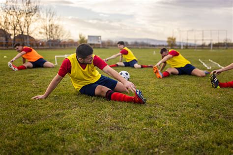 축구장에서 훈련하기 전에 스트레칭과 워밍업을 하는 남성 축구 선수 경기장에 대한 스톡 사진 및 기타 이미지 경기장 앉음 축구 Istock