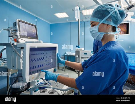 Nurse In Operating Room Of Hospital Checking Patients Vital Signs
