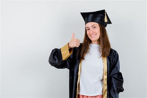 Graduada Femenina Mostrando El Pulgar Hacia Arriba En Traje Académico Y