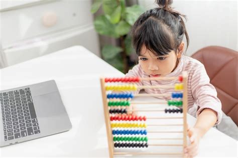 Premium Photo A Young Cute Asian Girl Is Using The Abacus With