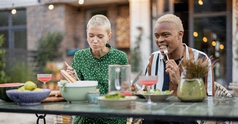 다인종 커플은 시골집 정원에서 저녁 식사 시간에 이야기하고 즐거운 시간을 보냅니다 따뜻한 대화와 관계에 대한 아이디어 함께 시간을 즐기는 라틴 남자와 유럽 여자 사진