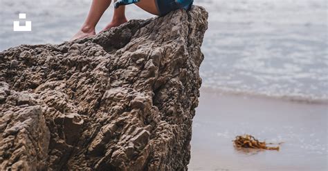 낮 동안 바다 근처 바위에 앉아 파란색과 흰색 꽃 드레스를 입은 여자 사진 Unsplash의 무료 엘 마타도르 비치 이미지
