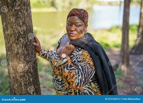 Beautiful Black Plus Sized Model Posing By A Tree In A Tranquil Park