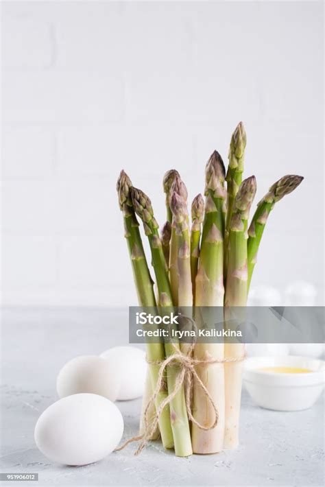 회색 콘크리트 바탕에 달걀과 원시 신선한 정원 유기 아스파라거스의 무리 건강 한 봄 아침 식사에 대 한 간단한 제품입니다 제조 법에 대 한 배경 텍스트를 위한 공간입니다