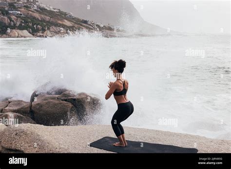 Woman Practicing Yoga While Standing On Stone Against Big Waves And Splashes Female Meditating