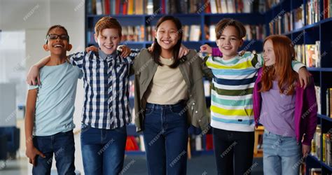 Premium Photo Portrait Of Multiethnic Classmates Hugging And Smiling At Camera In School Library