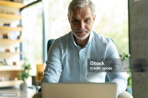 사무실 로비에 앉아서 노트북으로 작업하는 웃는 사업가 사무실 로비에서 일하는 남성 비즈니스 전문가 40 49세에 대한 스톡 사진 및 기타 이미지 Istock