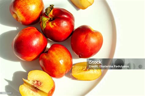 자연 배경에 흰색 접시에 붉은 잘 익은 유기농 넥타린 과일입니다 여름 건강 한 먹는 개념 과일 항산화제 선택적 초점 위쪽 보기