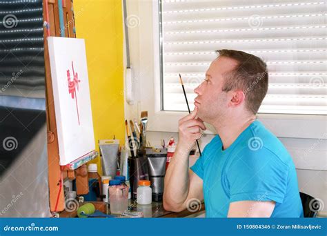 Pintor De Sexo Masculino Del Artista Que Trabaja En Taller Con La Lona En El Caballete De Madera